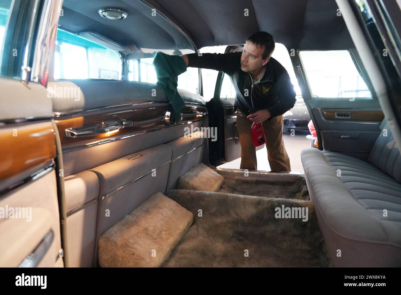 Salesman Tyler Leighty wipes down the patition glass in a 1964 Imperial ...