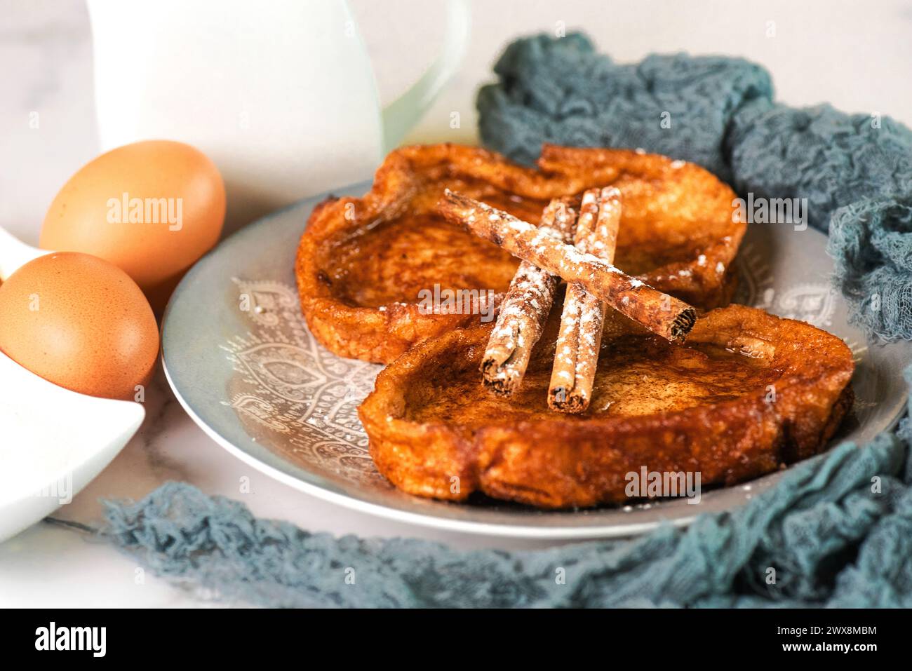 Plate with traditional homemade Torrijas, cinnamon stick,milk and eggs ...