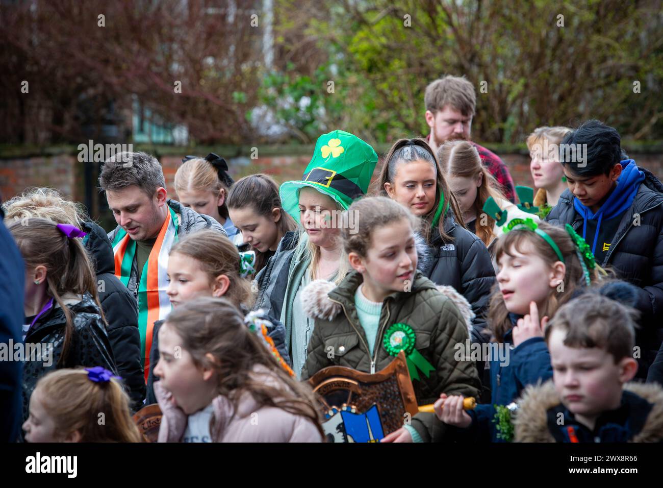 Blonde lady in a Leprechaun hat walks with the crowd during the 2024 ...