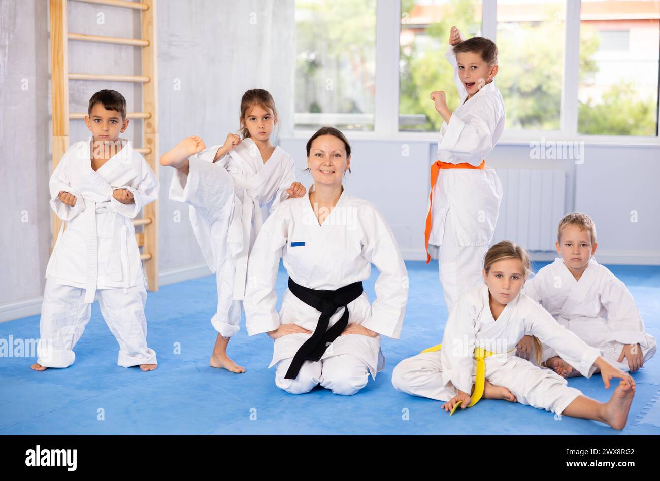 Portrait of female karate or judo coach with her students little ...