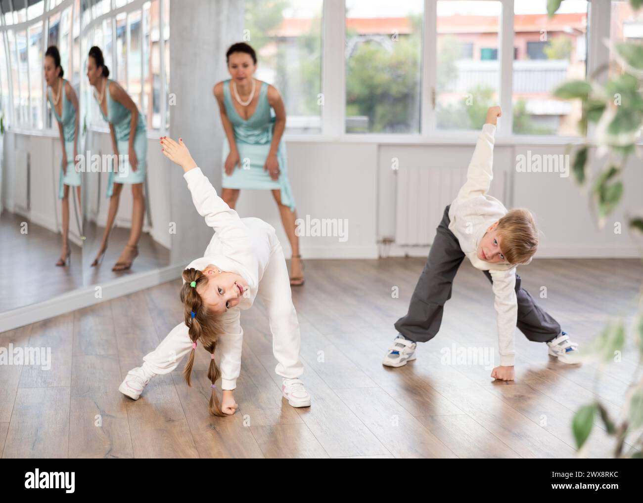 Tween girl and boy rehearsing popping techniques in street dance studio ...