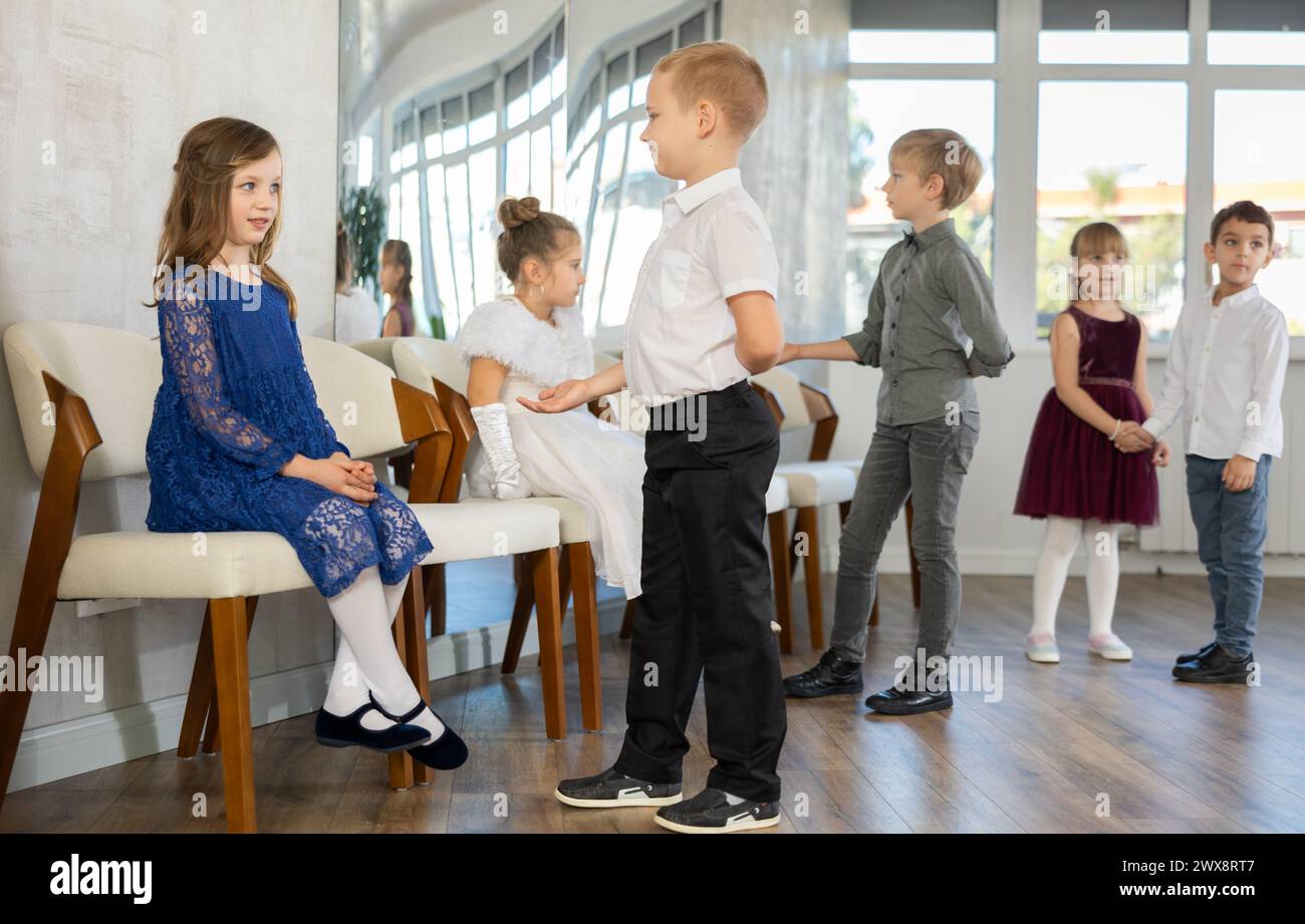 Preteen boy inviting girl to dance during children festive event Stock ...
