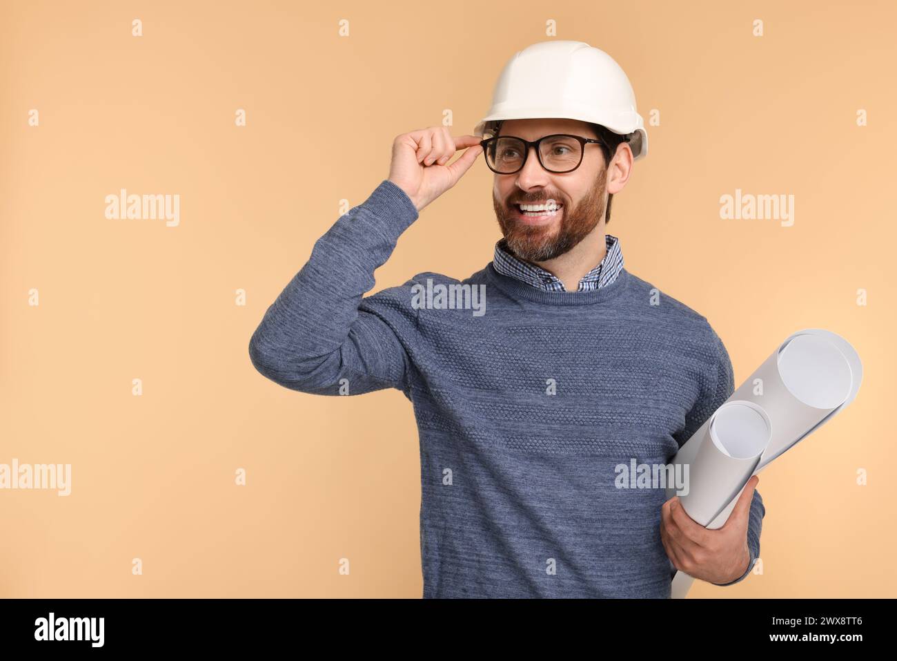 Architect in hard hat with drafts on beige background, space for text ...
