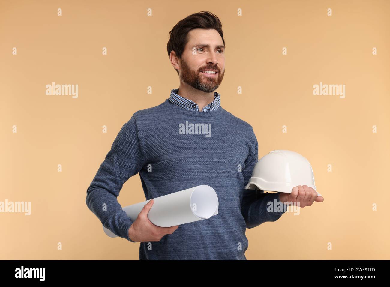 Architect with hard hat and draft on beige background Stock Photo - Alamy
