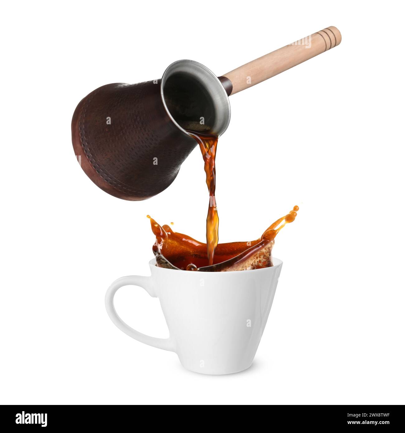 Pouring freshly brewed aromatic coffee from turkish pot into cup ...