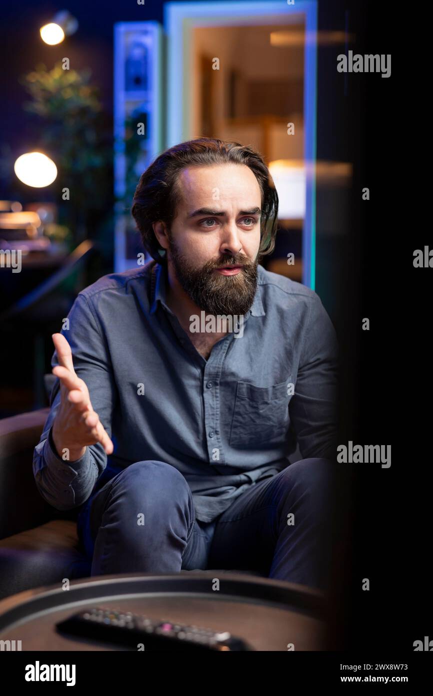 Man watching movies at home on TV, engrossed by riveting action, paying ...