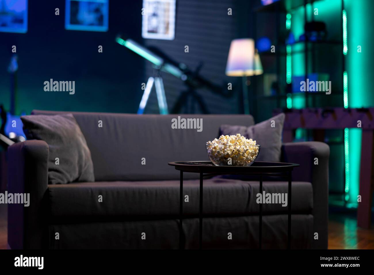 Bowl of popcorn on coffee table in front of cozy furniture in empty ...