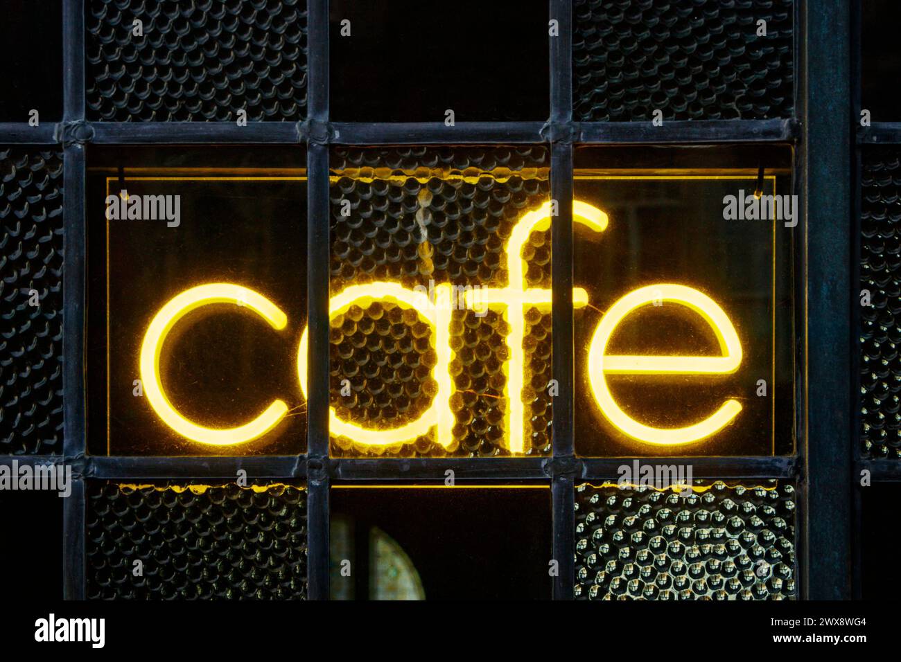illuminated neon cafe sign behind a mottled glass window in Blyth ...