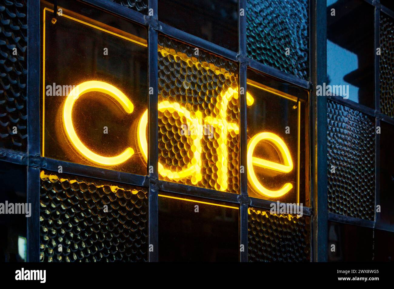 illuminated neon cafe sign behind a mottled glass window in Blyth ...
