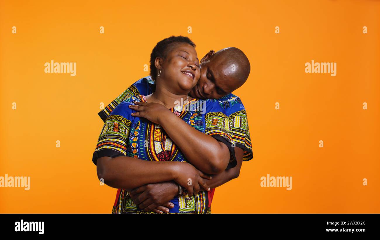 Sweet african american couple embracing in studio, holding each other ...