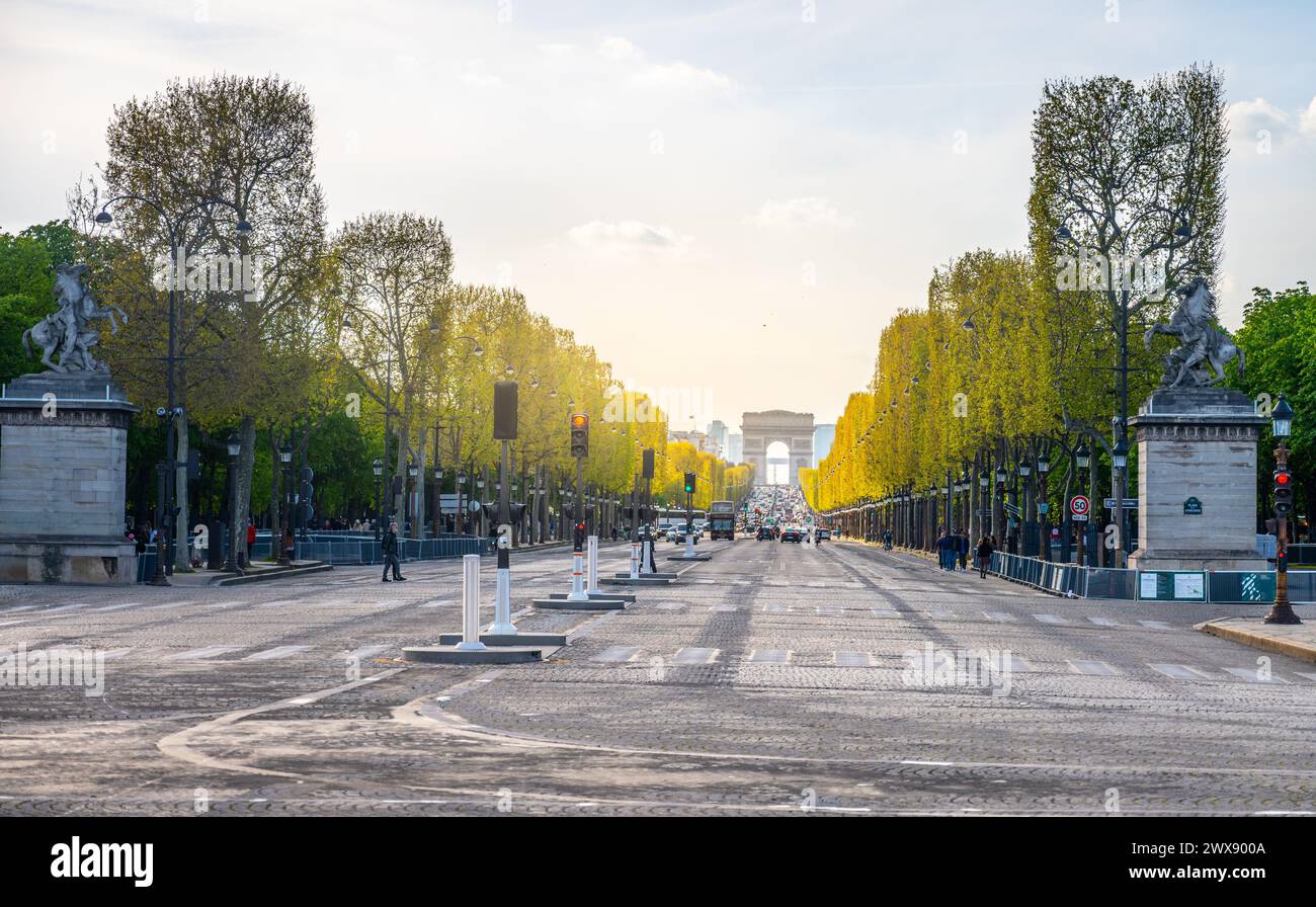 The sun casts a warm glow on the Avenue des Champs-Elysees leading up ...