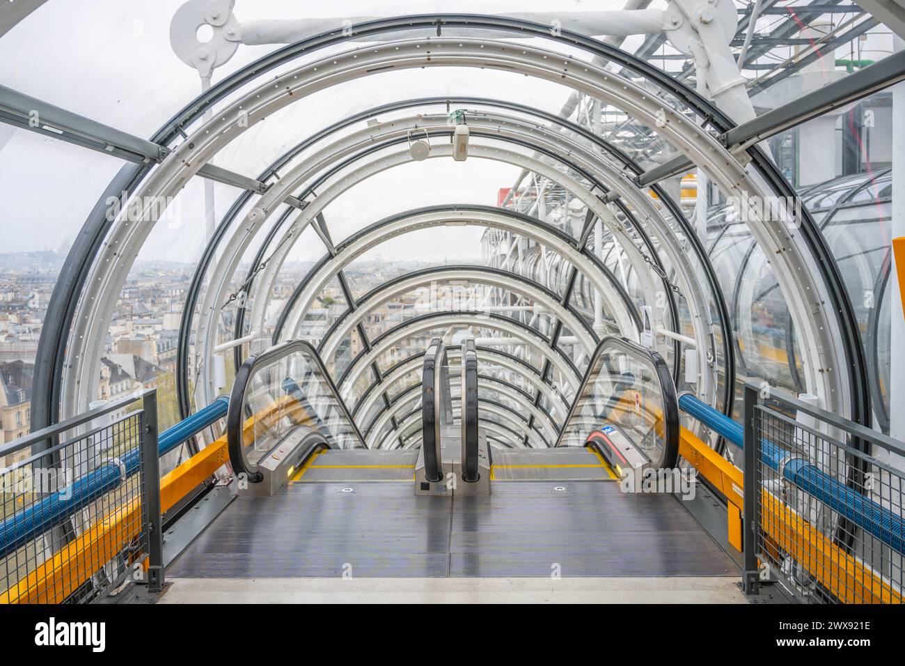 An enclosed escalator passes through a transparent tunnel providing a ...