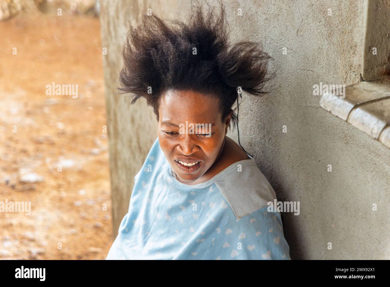 african woman with crazy hairstyle standing in front of the house ...