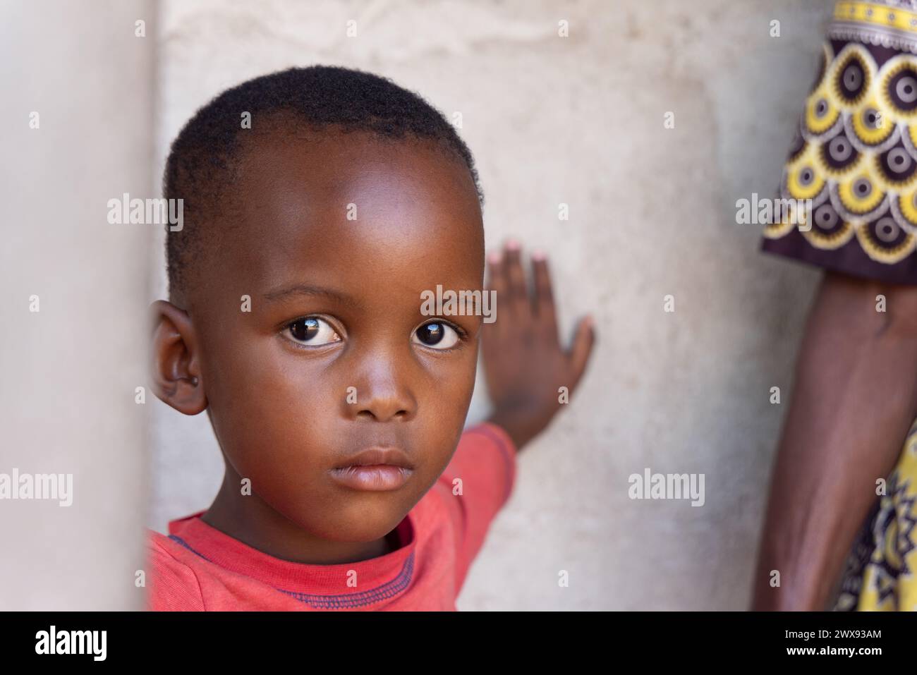portrait african child sited on the porch in front of the house ...