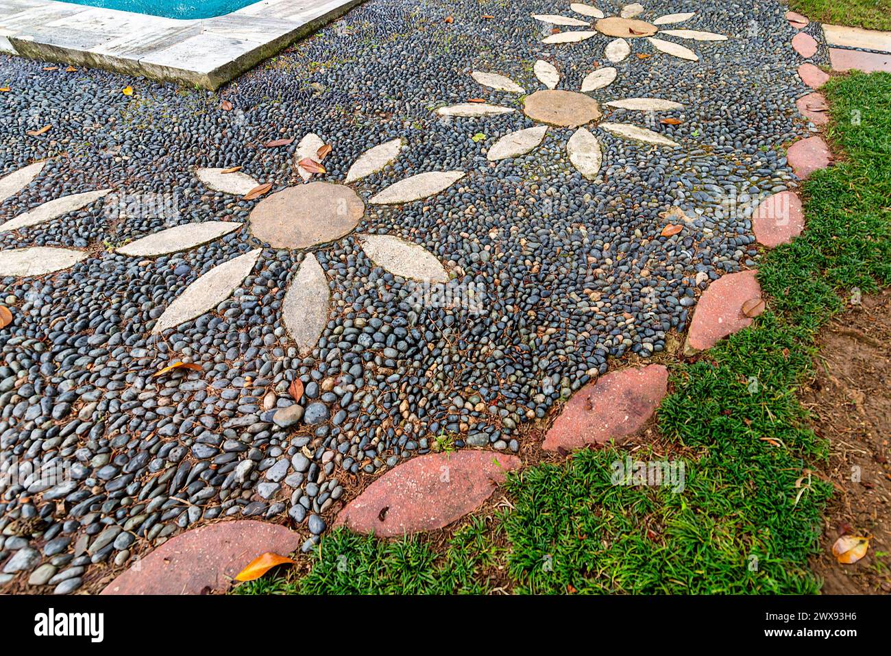 A pathway features intricate pebble mosaic designs, creating floral ...