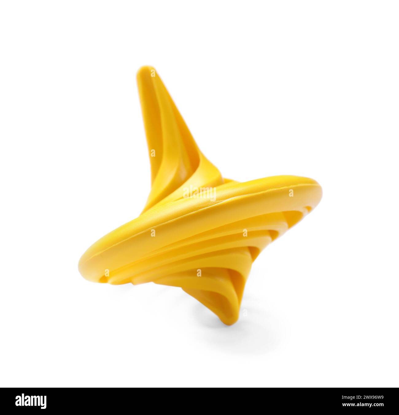 One yellow spinning top on white background Stock Photo - Alamy