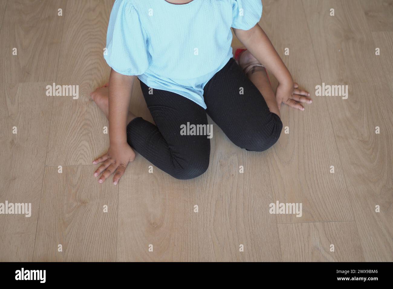 child sitting W posture on the floor Stock Photo - Alamy