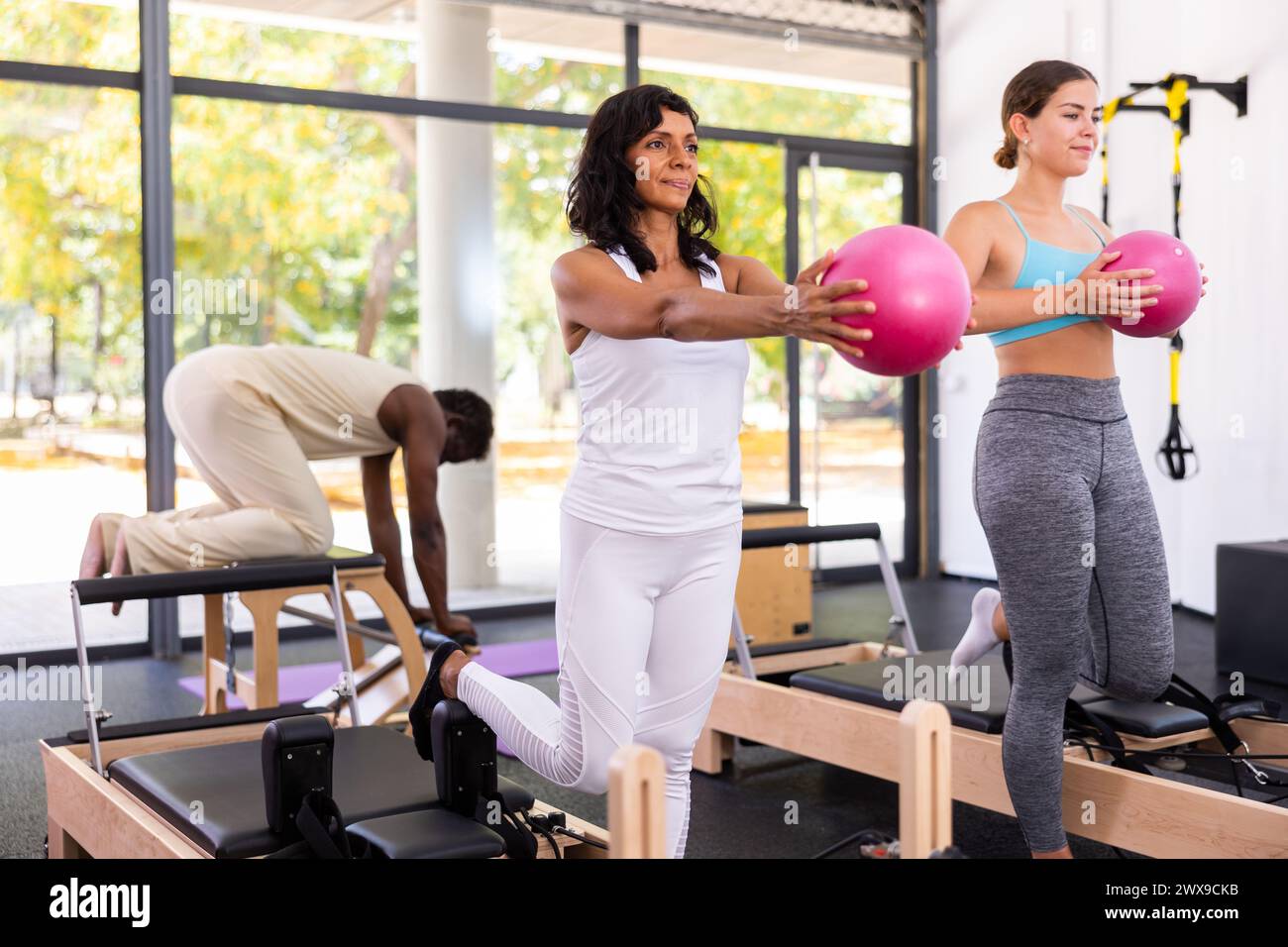 Portrait of two young sporty woman during group core training with ...