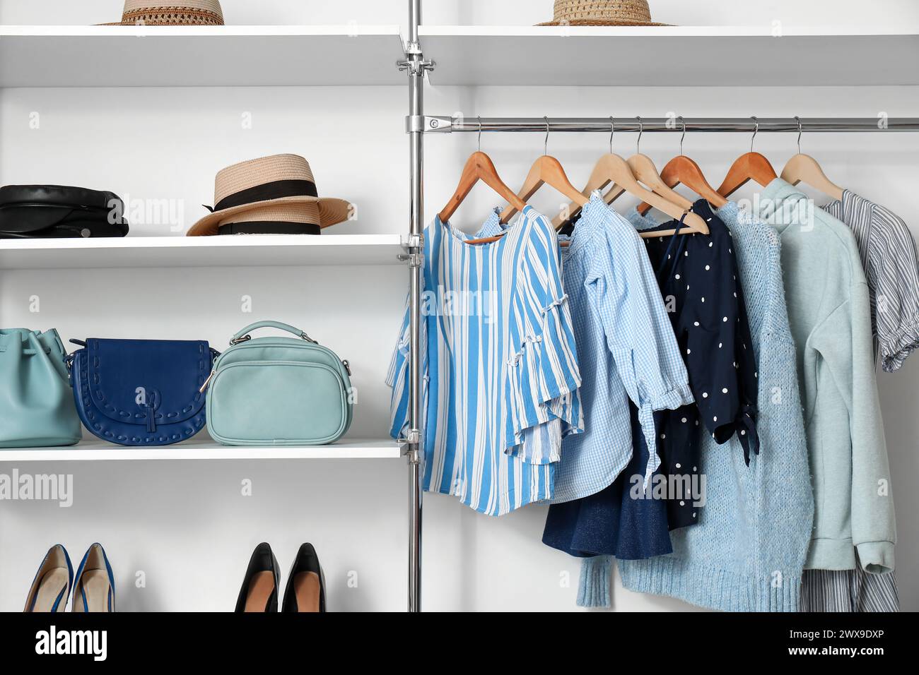 Rack with stylish female clothes and accessories in modern wardrobe ...