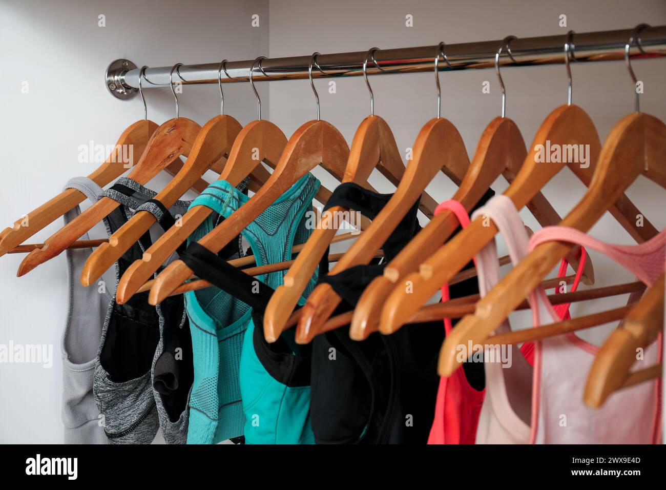 Rack with stylish sports bras in modern wardrobe Stock Photo - Alamy