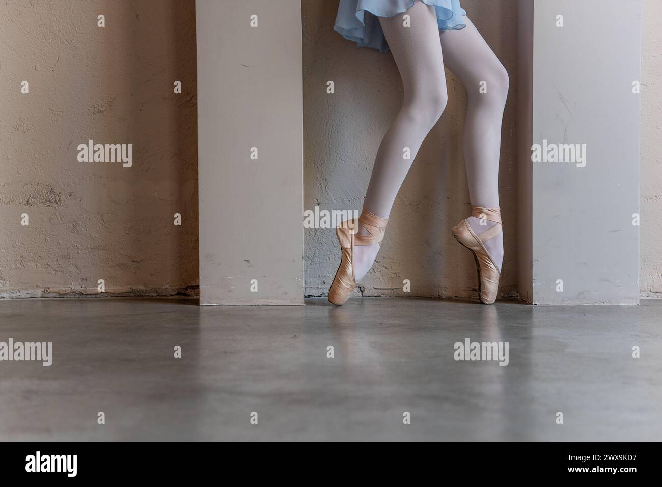 Close up faceless young ballerina in blue costume stands en pointe ...