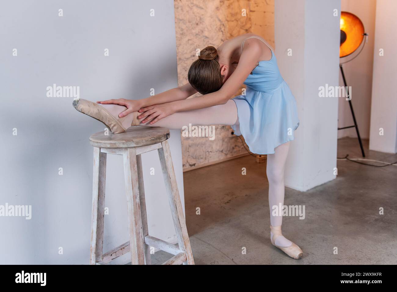 Ballerina in pointe Stretching by a Stool in Studio. Ballet dancer in ...