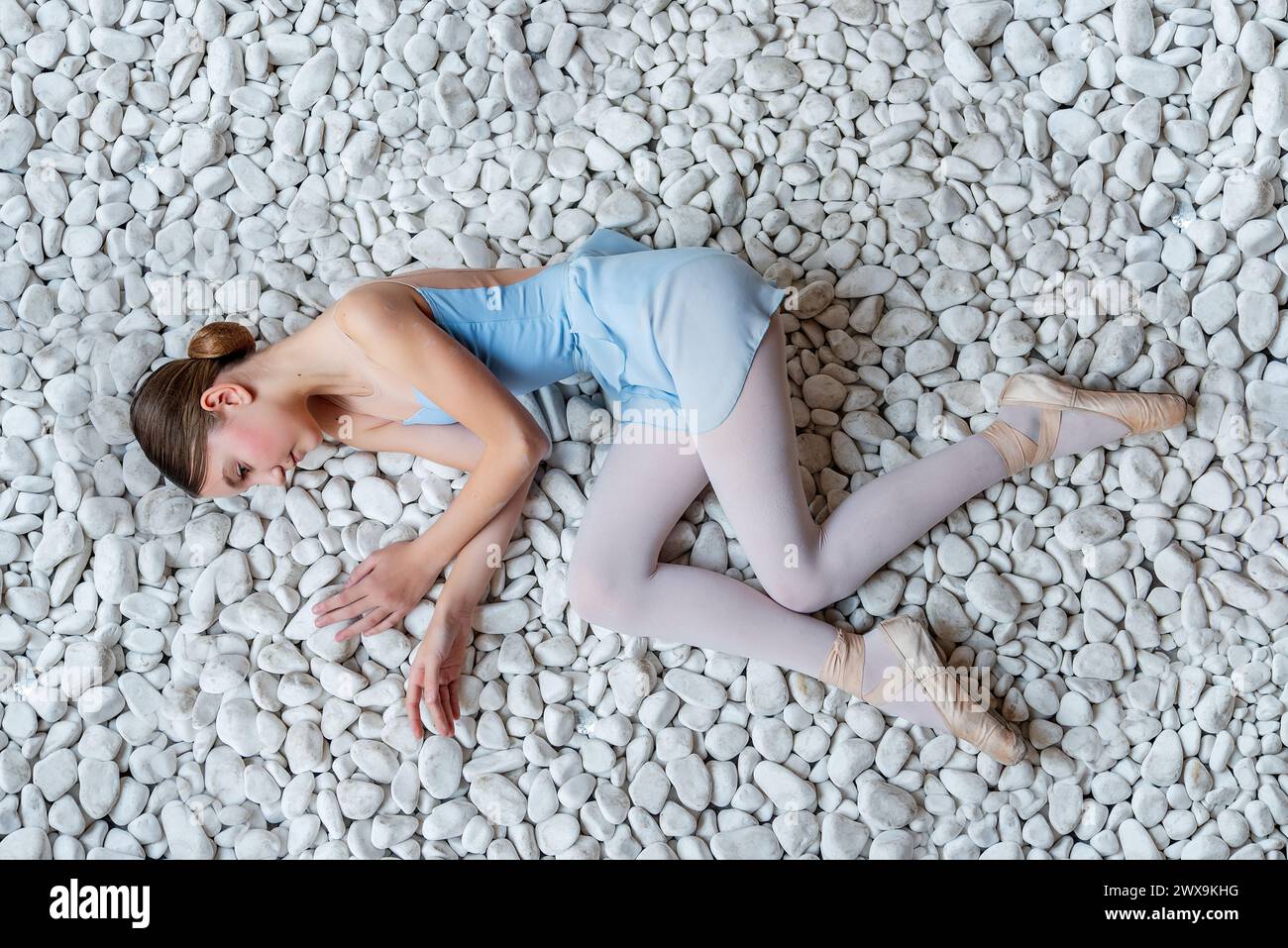 Top view ethereal ballet dancer in blue leotard, tights lies gracefully ...