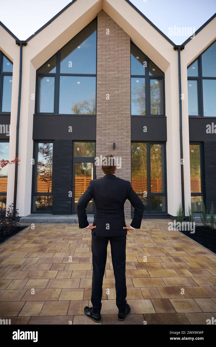 Back view photo of man standing in front of building Stock Photo - Alamy