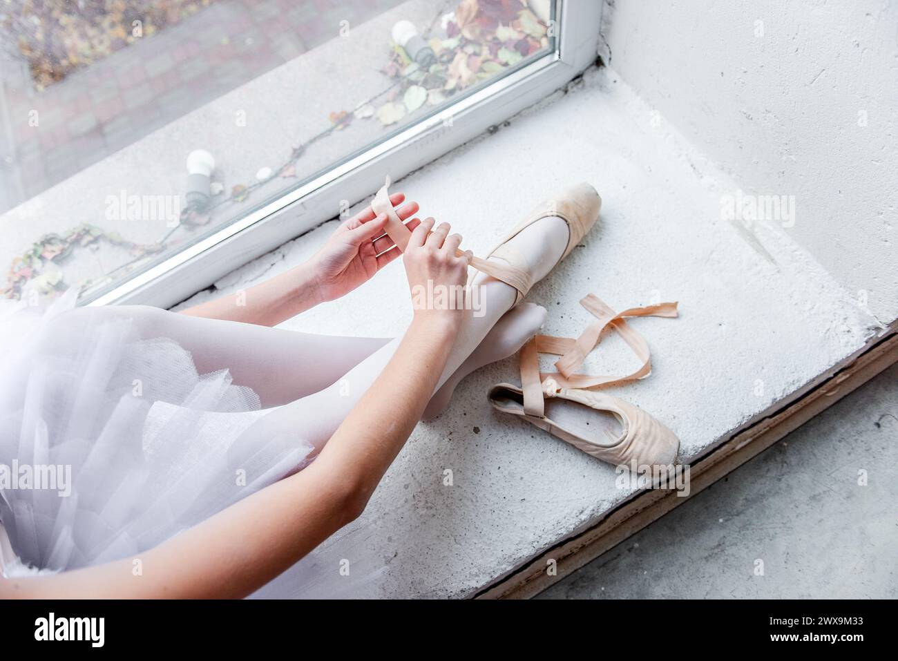 Overhead view captures a ballerina seated by a bright window ...