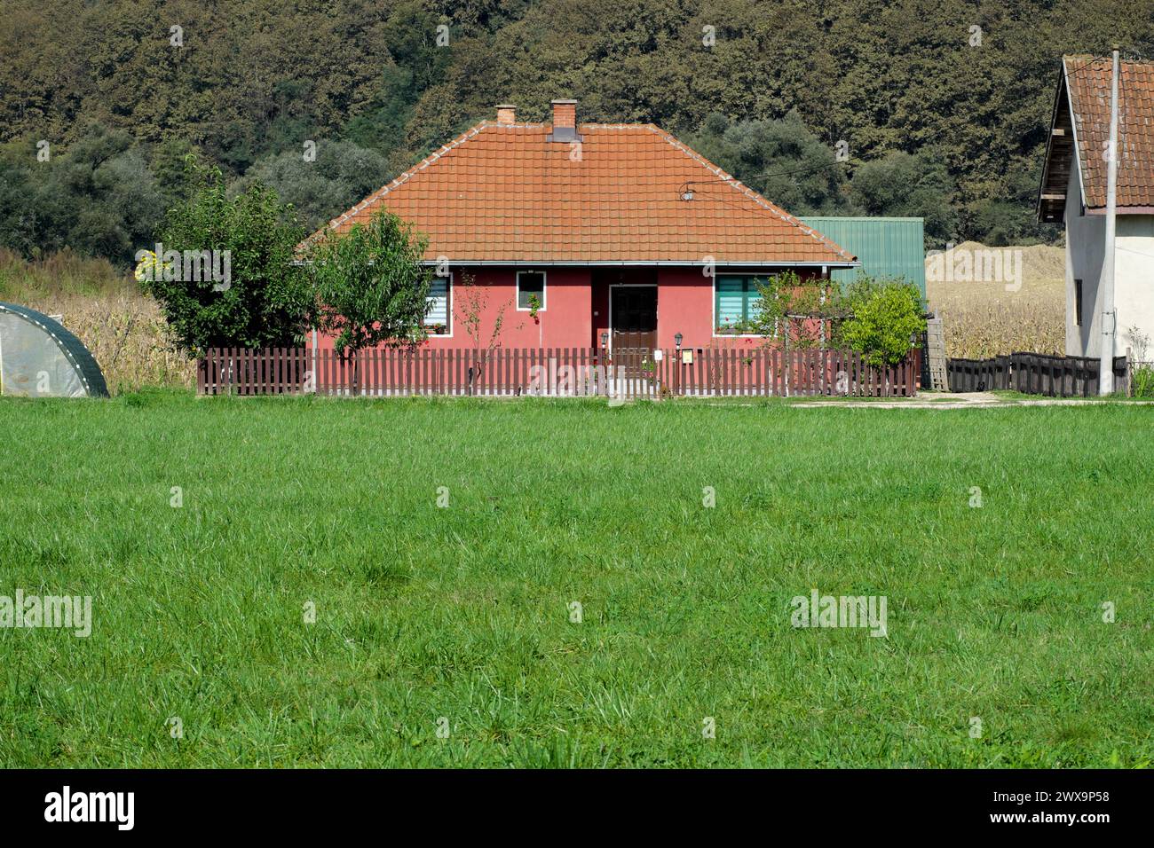 small, simple house with fence in Serbia Stock Photo - Alamy