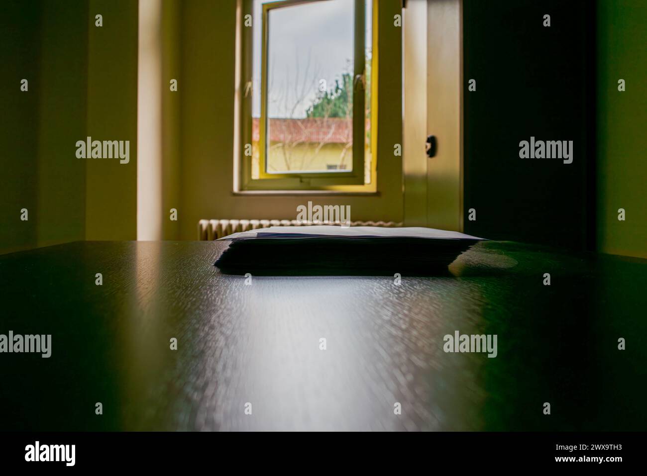 A pristine desk adorned with neatly stacked white A4 papers, creating ...