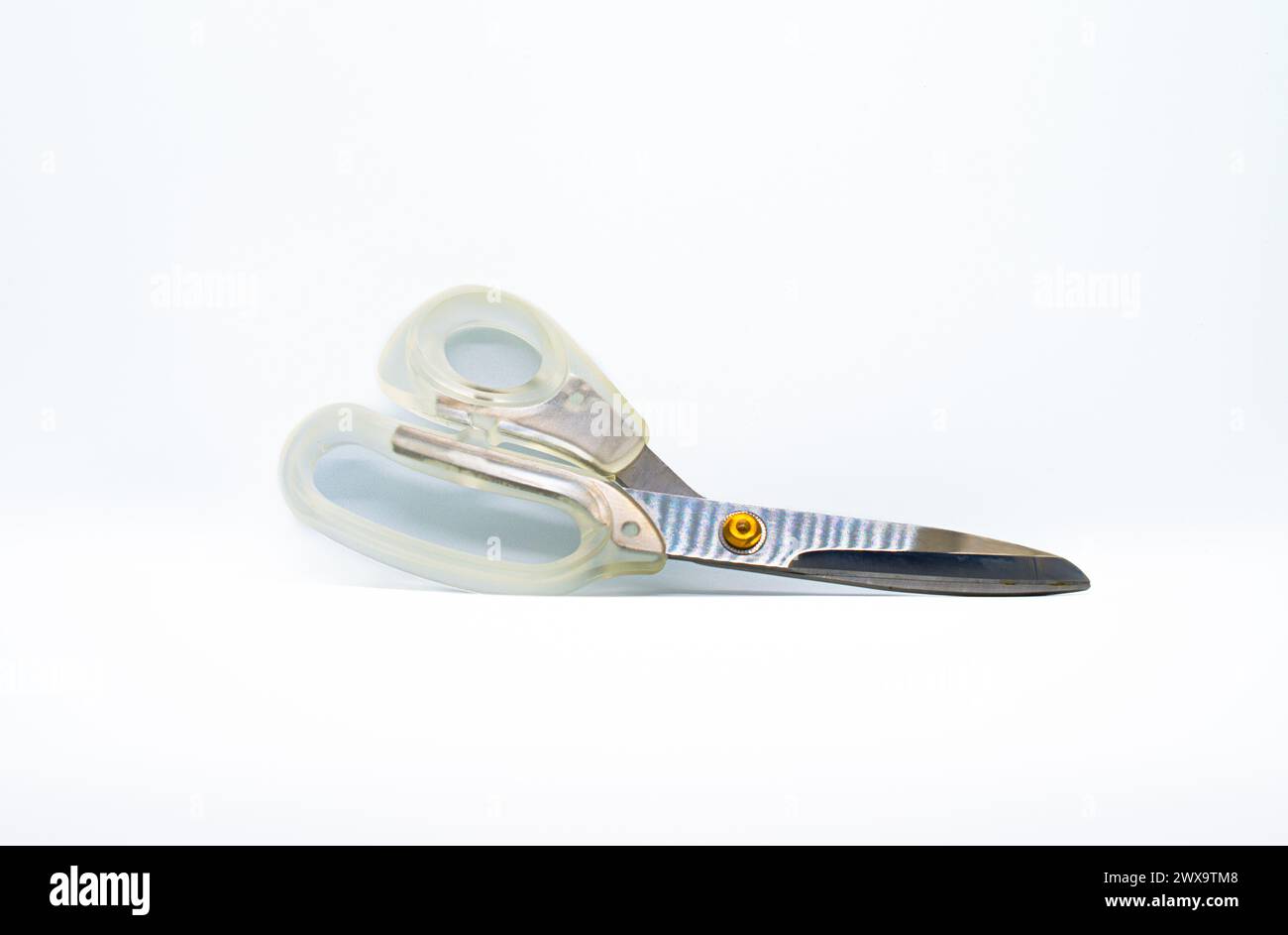 A single scissor on a white background stands ready, epitomizing ...