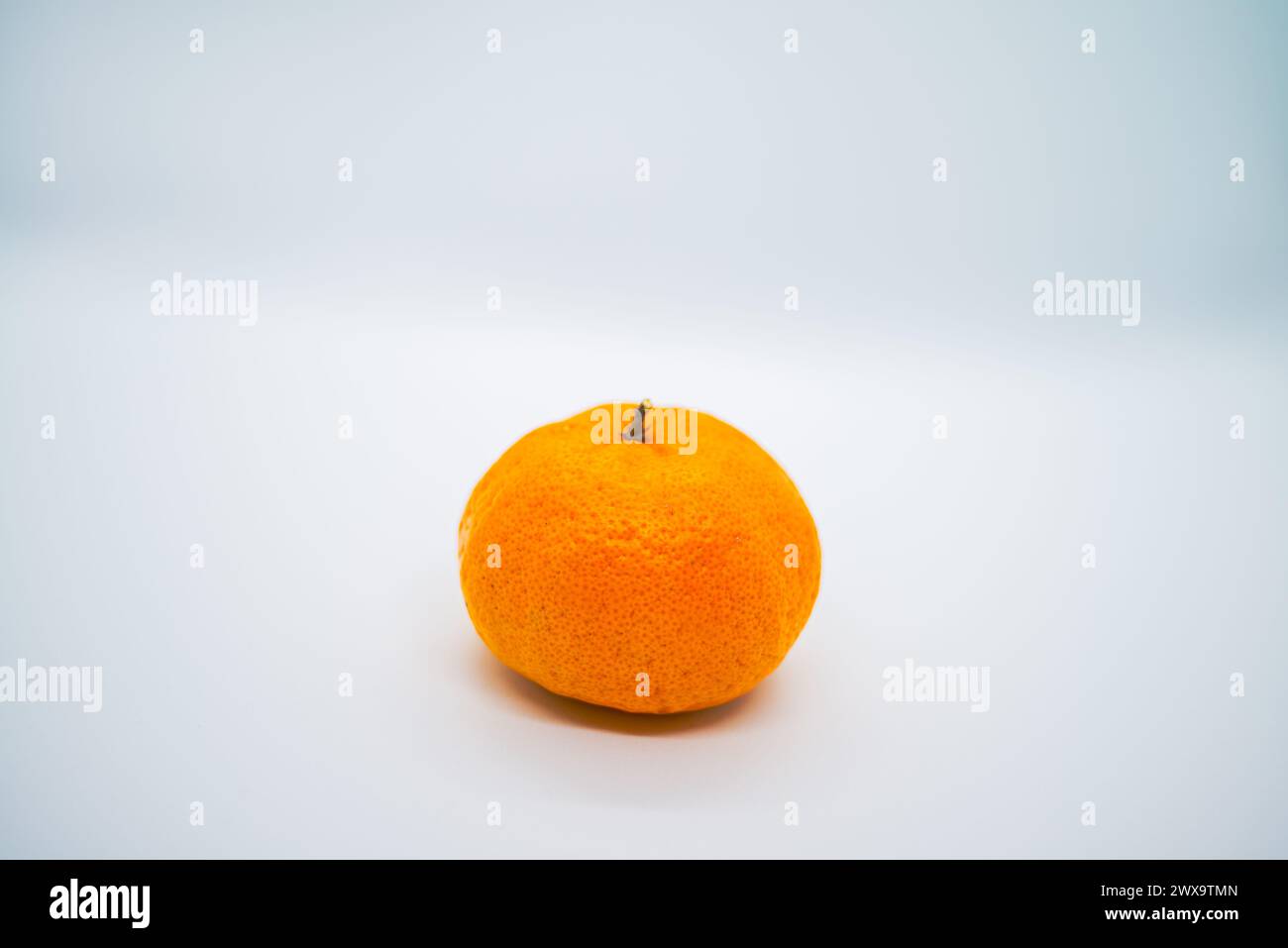 A mandarin-whitebackground showcases a vibrant, juicy citrus fruit ...