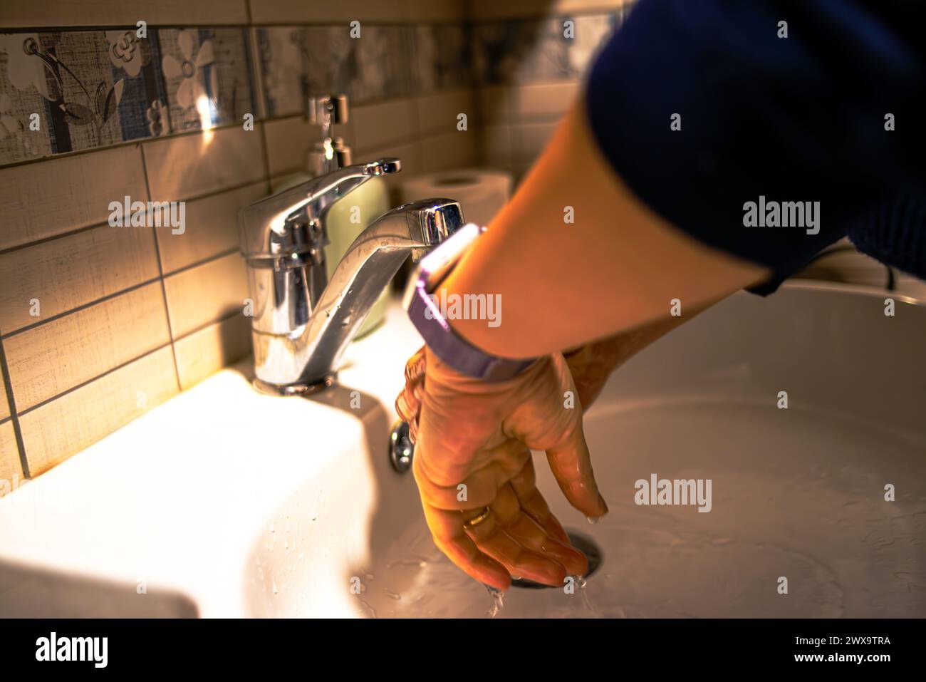 A woman diligently washes her hands, taking precautions against ...