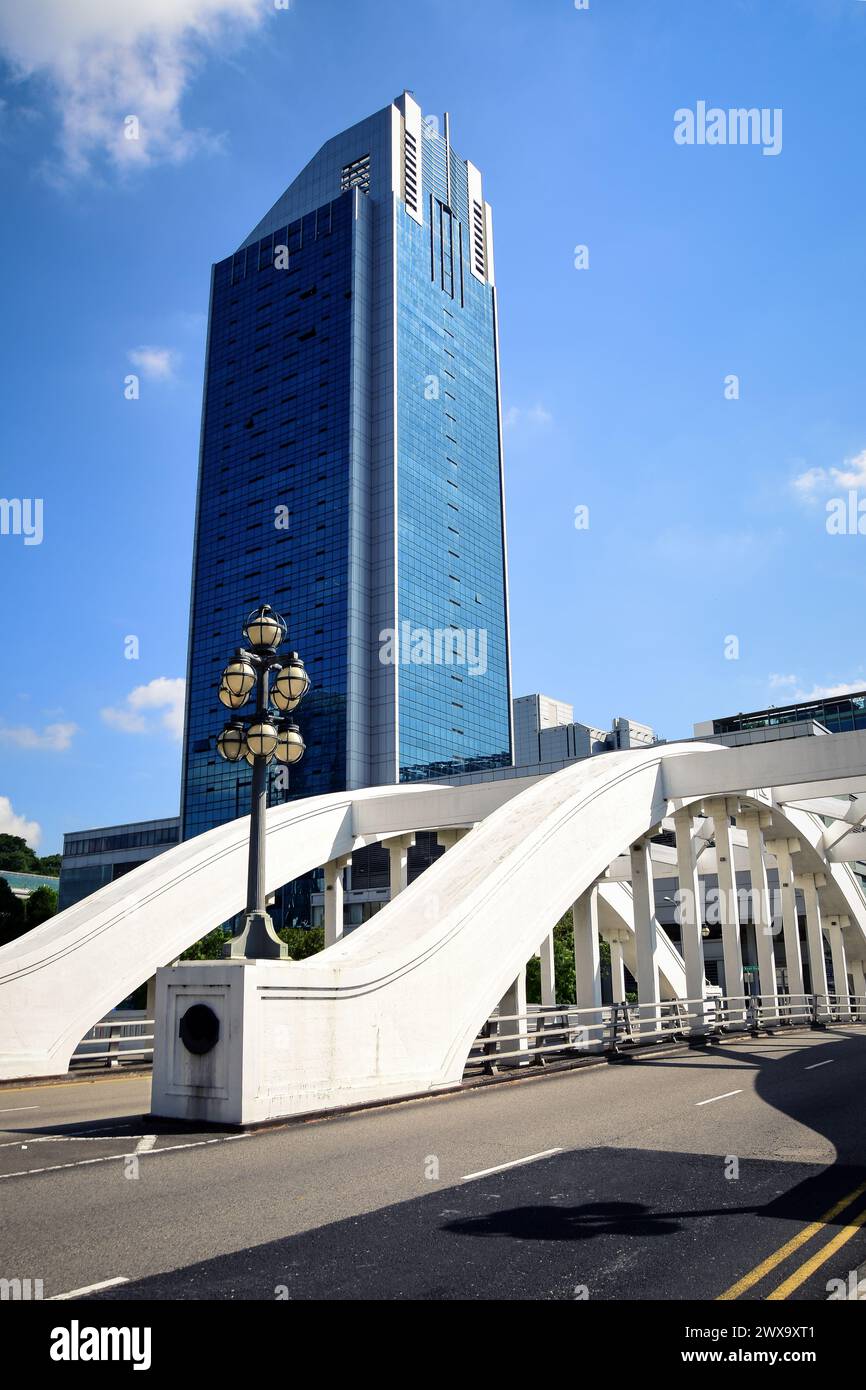 An arched bridge over a street with a skyscraper in the background ...