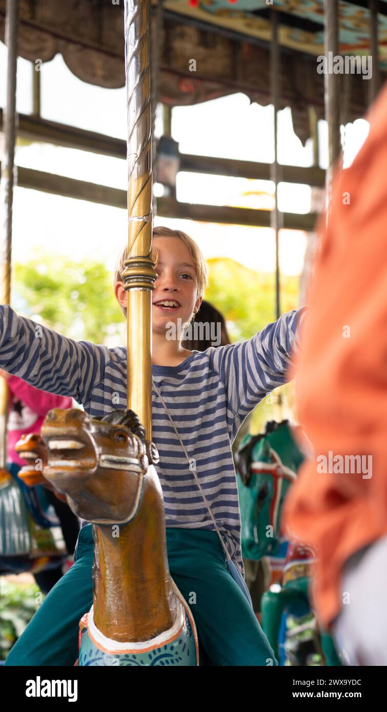 Boy riding a carousel in an amusement park Stock Photo - Alamy
