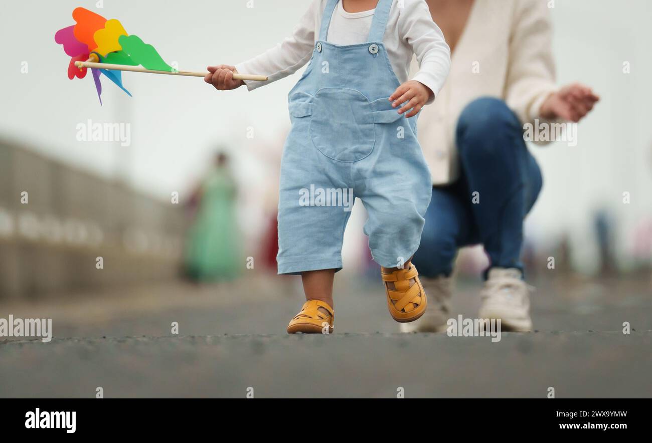 close up leg of infant baby walking on a path with mother helping Stock ...
