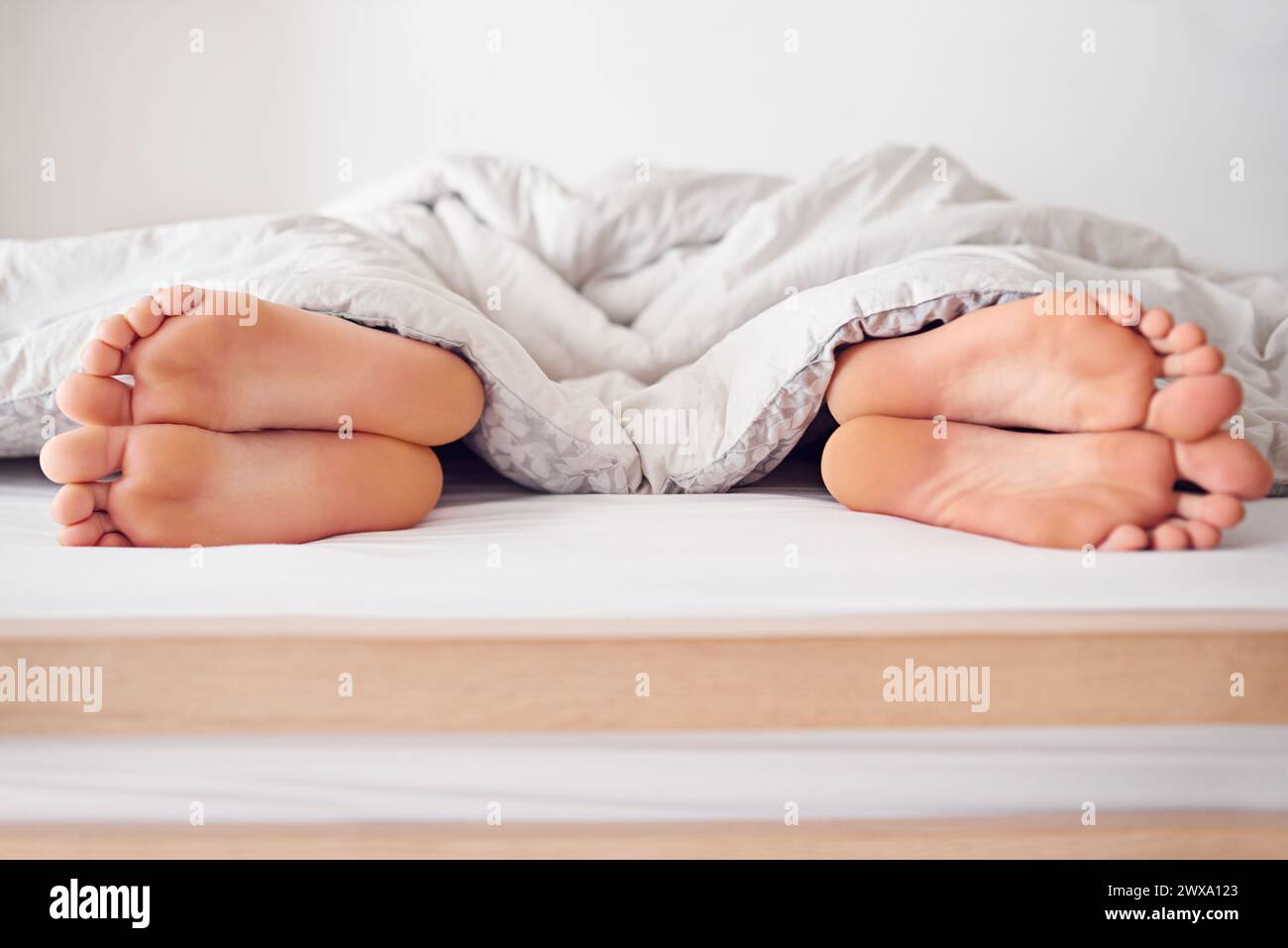 Couples feet in bed blanket hi-res stock photography and images - Alamy