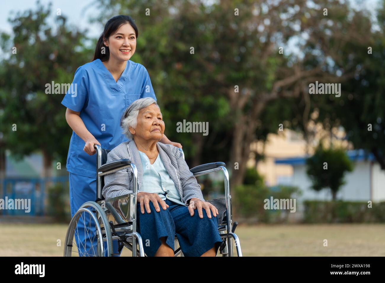 happy nurse take care and pushing senior woman in wheelchair at the ...