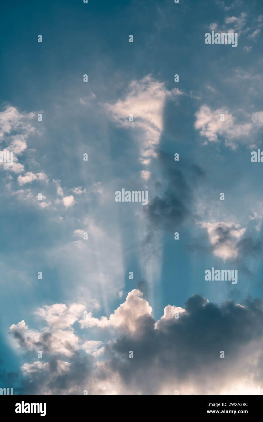 Vertical blue sky with clouds and sun shining through Stock Photo - Alamy