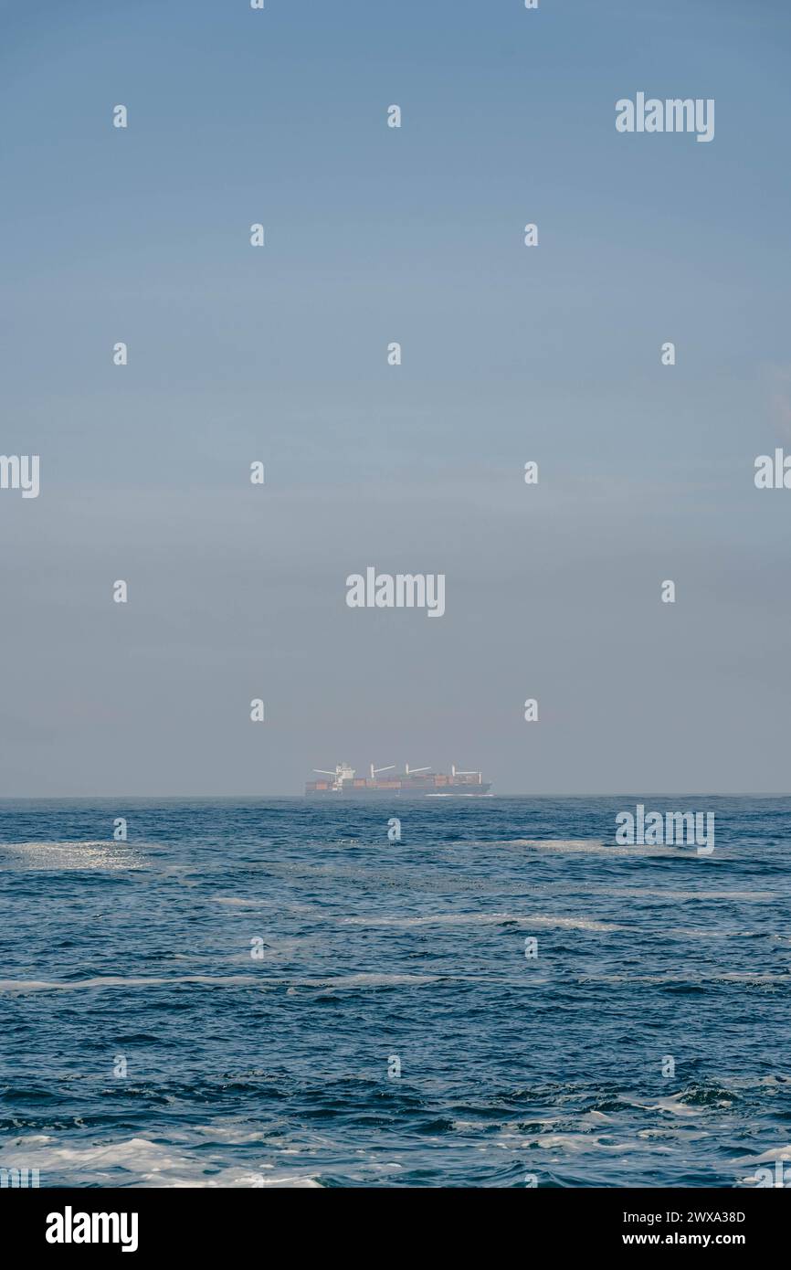 Container cargo ship in the ocean, blue sky background with copy space ...