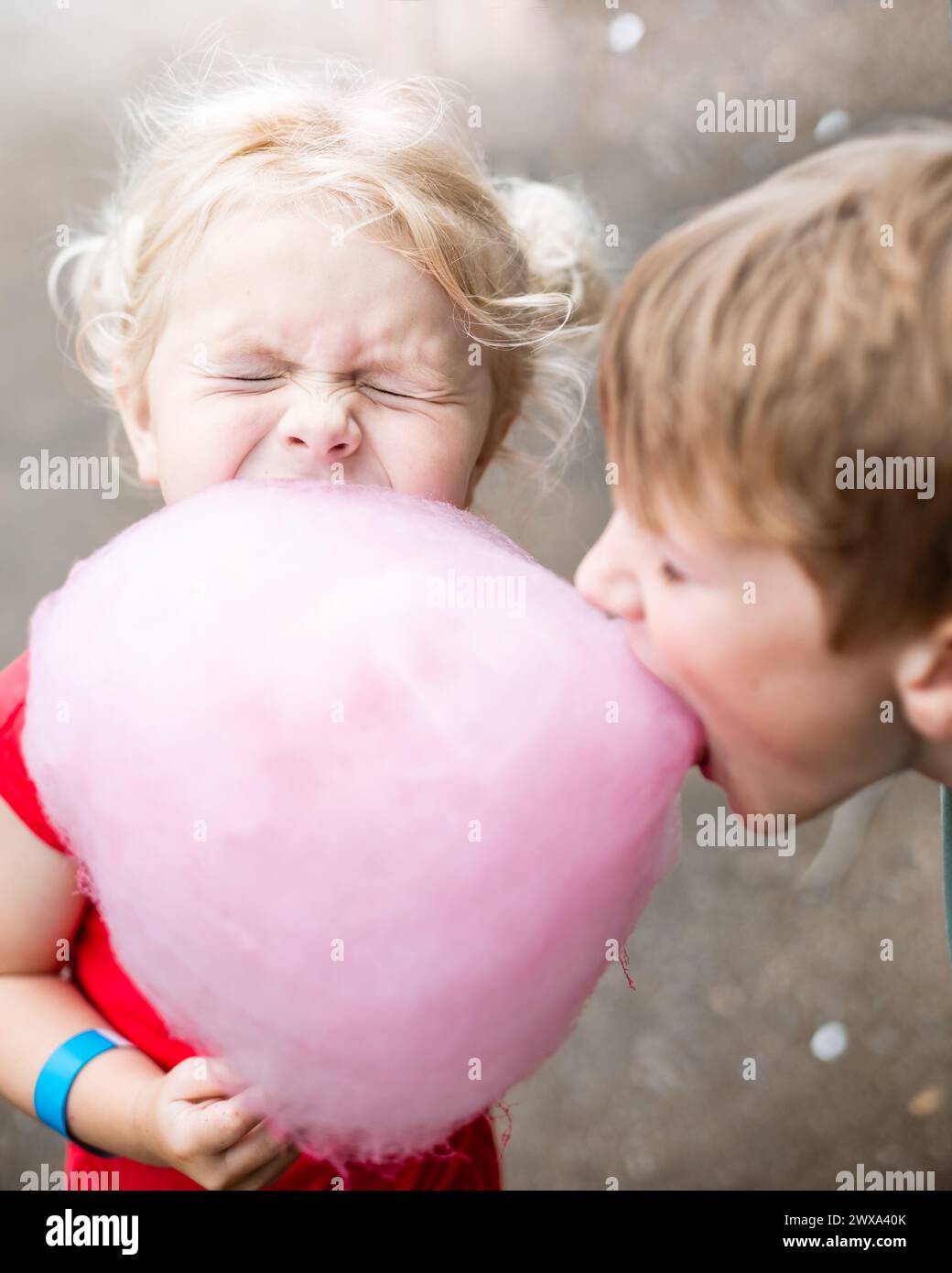 Kids sharing cotton candy at carnival Stock Photo - Alamy