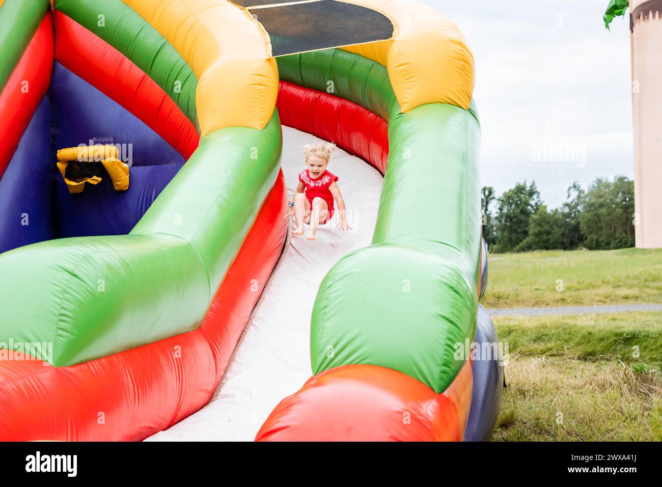 Young child bouncing down inflatable slide Stock Photo - Alamy