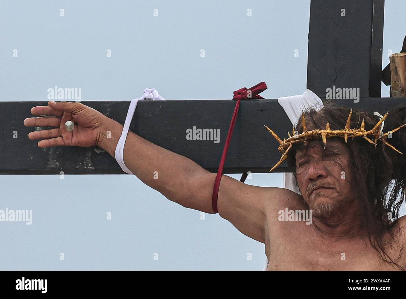 Ruben Enaje remains on the cross during a reenactment of Jesus Christ's ...