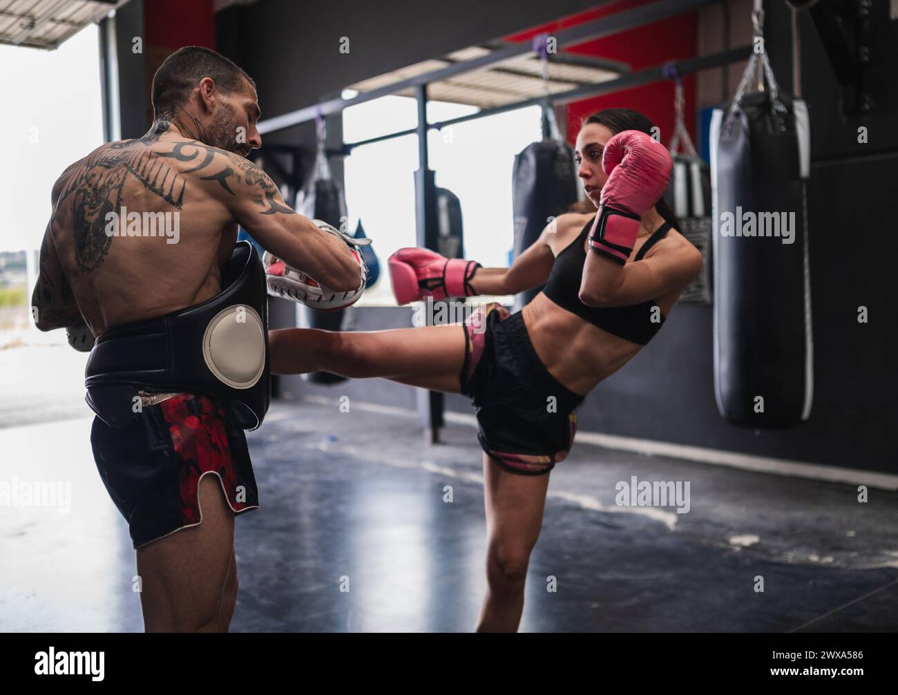 Female fighter practicing martial arts kicks with coach Stock Photo - Alamy