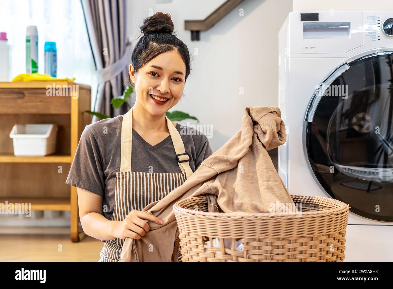 A Southeast Asian woman washing clothes in a laundry room Stock Photo - Alamy