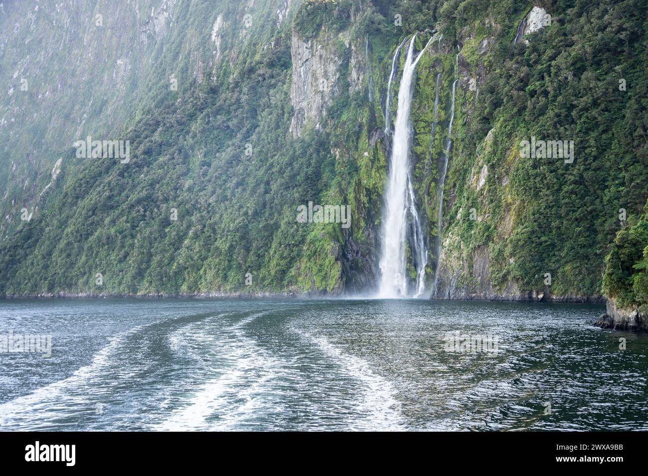 Beautiful majestic waterfall in fjord falling into sea in Fiordland ...