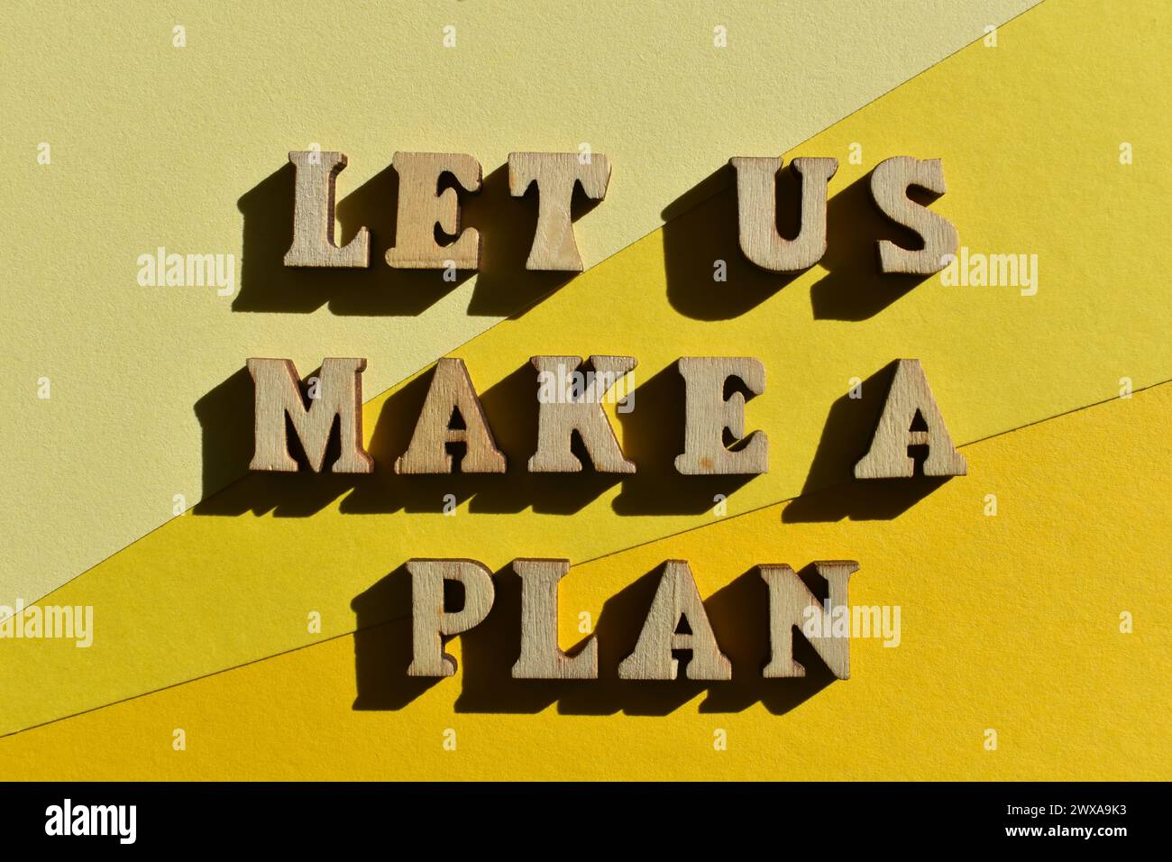 Let Us Make A Plan, words in wooden alphabet letters isolated on yellow ...