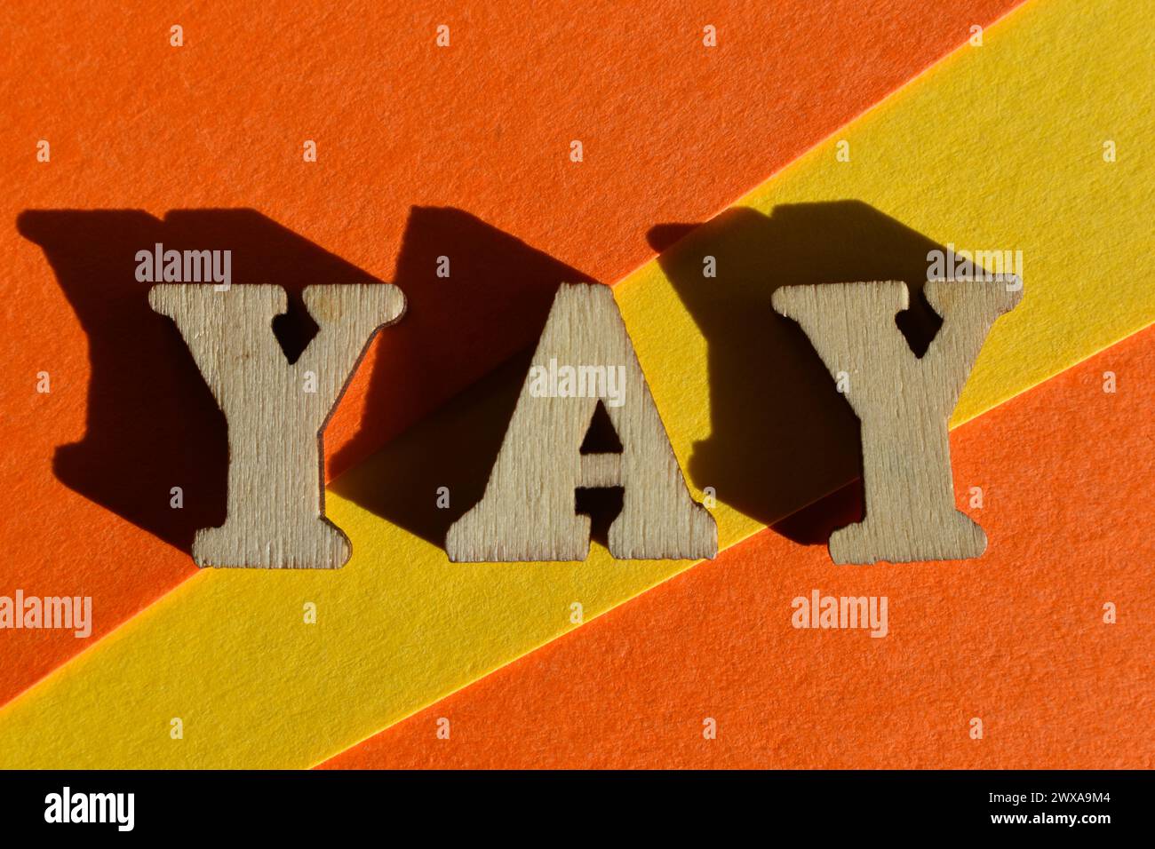 Yay, word in wooden alphabet letters isolated on bright yellow and ...