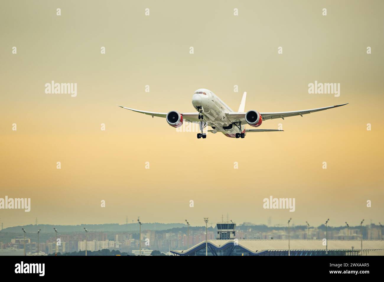 A passenger plane with landing gear for takeoff rising from an airport ...